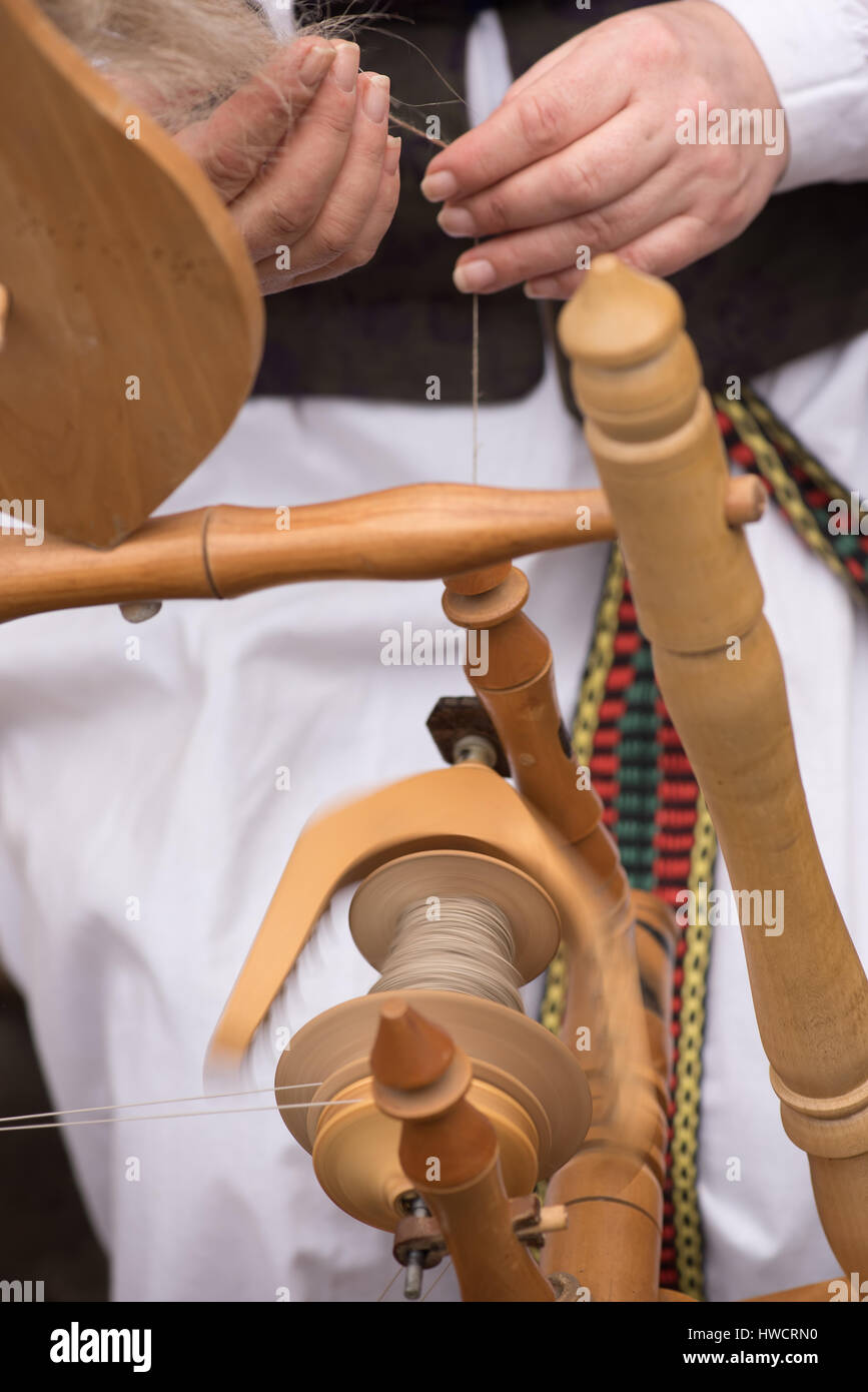 Hands of woman spinning wool into yarn with a spinning wheel Stock ...