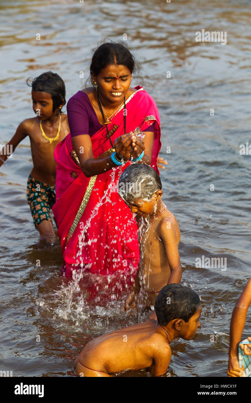 Indian woman bathing his son at Tungabhadra river, Hampi, Karnataka ...