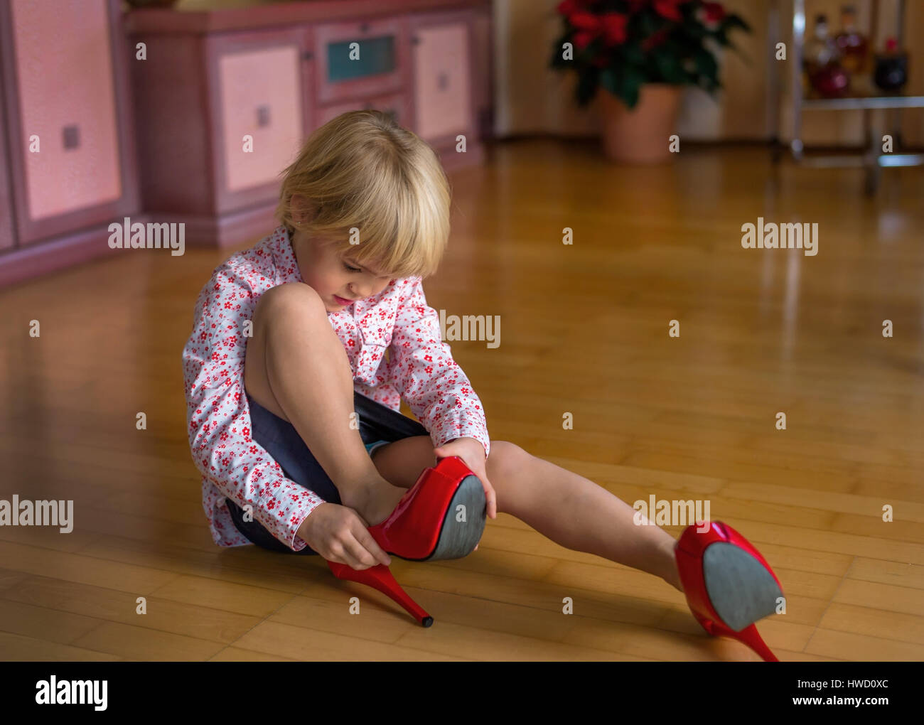 A child tries the big shoes of an adult. Symbol: Live in grand style ...