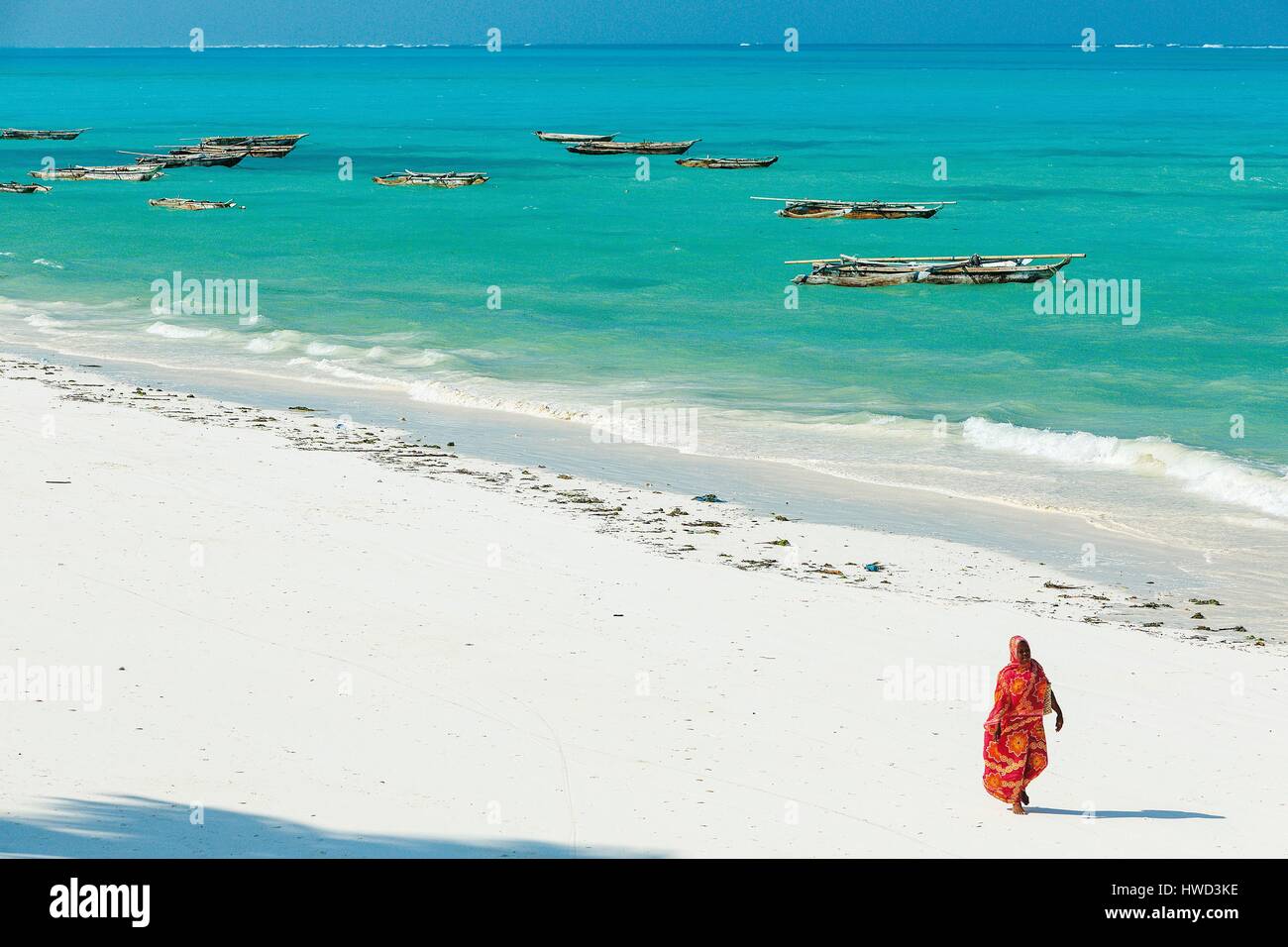 Tanzania, Zanzibar, Jambiani, veiled woman walking on a white sandy ...