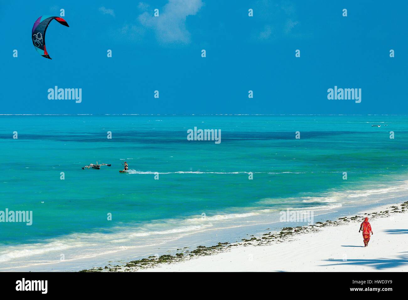 Tanzania, Zanzibar, Jambiani, veiled woman walking on a white sandy ...