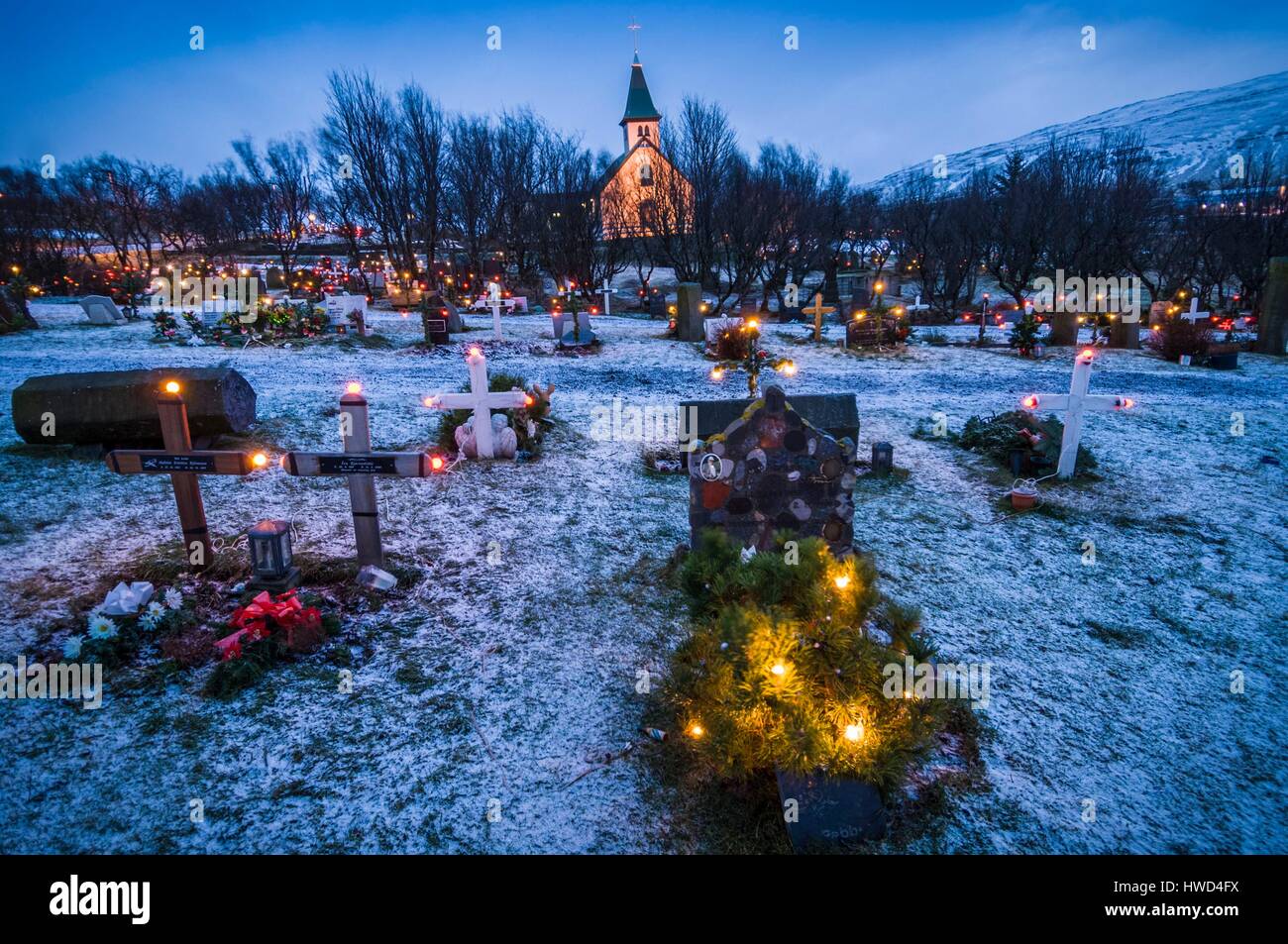Iceland, Mosfellsbaer, Lágafell Kirkja and graveyard illuminated in the ...