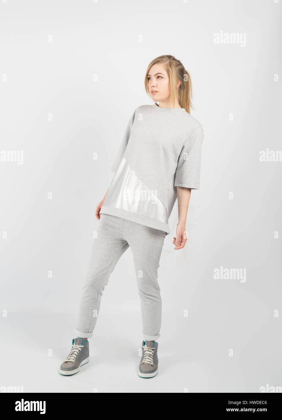 Young beautiful girl wearing grey clothes and sneakers posing isolated ...