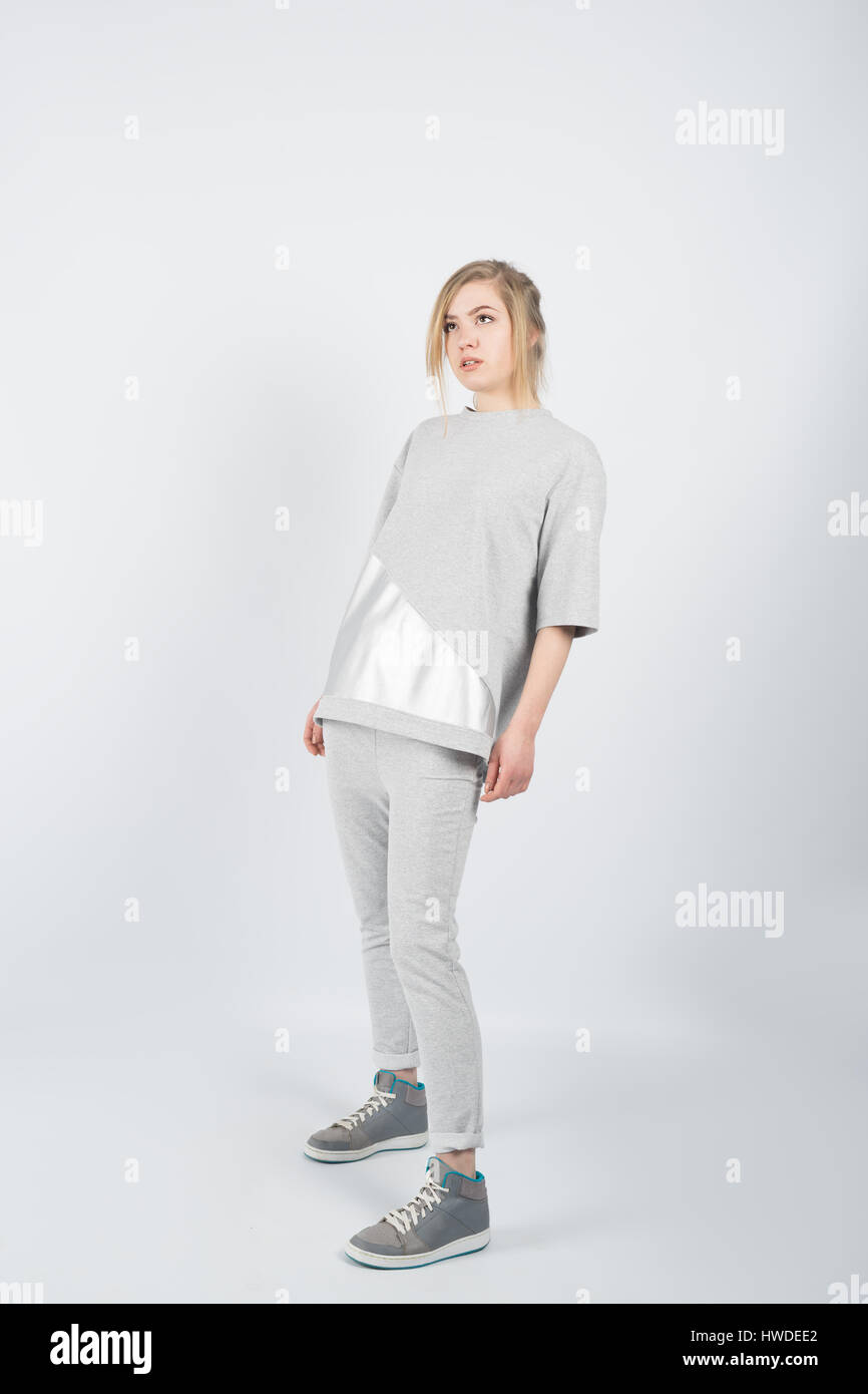 Young beautiful girl wearing grey clothes and sneakers posing isolated ...