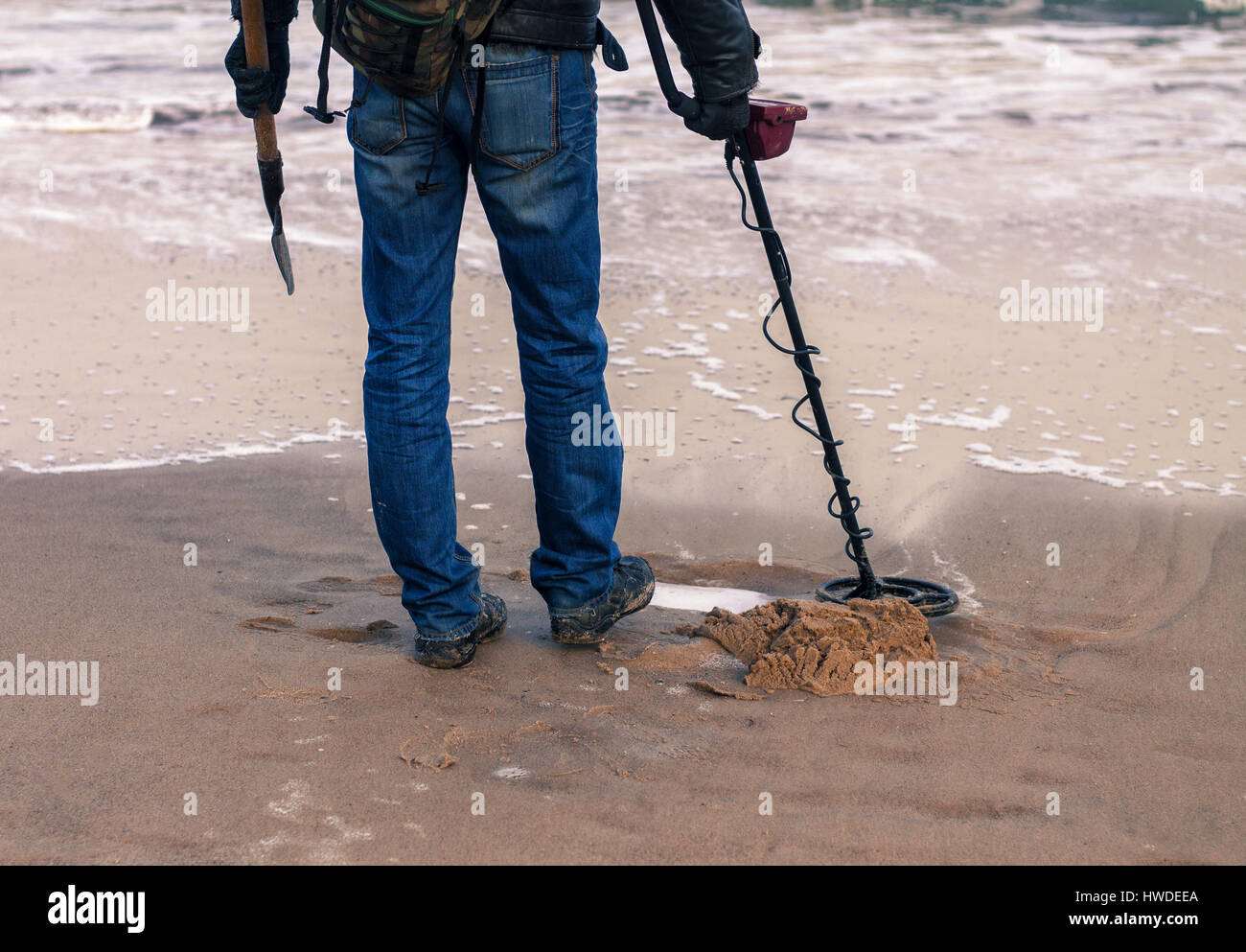 man using a metal detector to search for metal or lost treasure on the ...