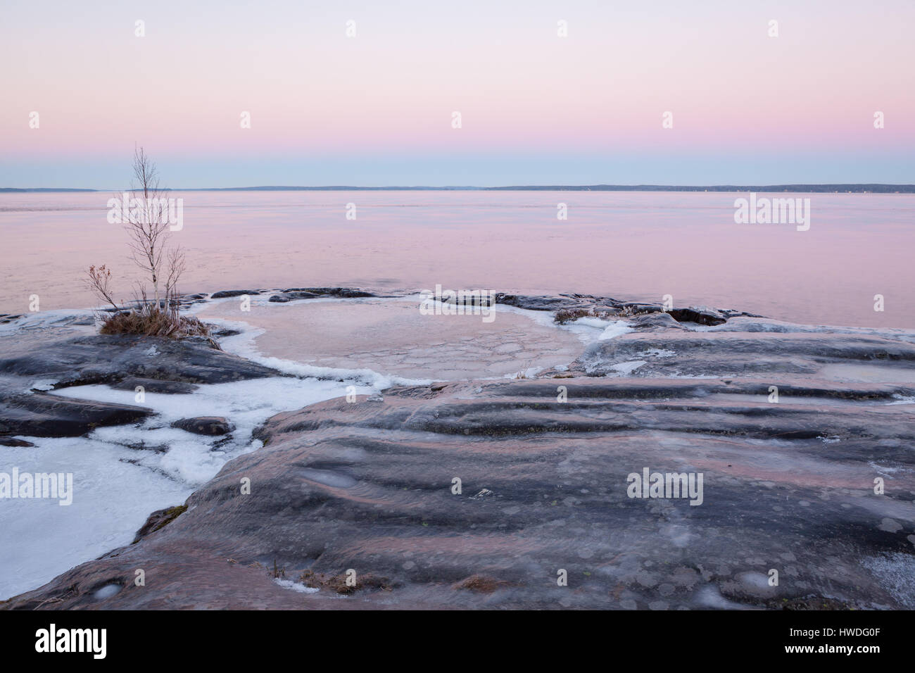 Frozen rock lake shore at dusk Stock Photo - Alamy