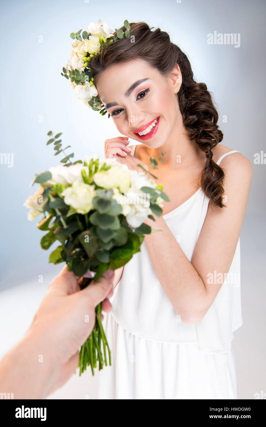 portrait of smiling woman receiving flowers bouquet on white Stock ...