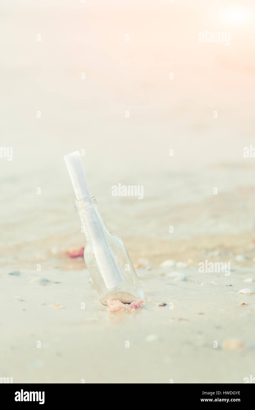 Bottle with a message or letter on the beach. SOS. Copy space. Help ...
