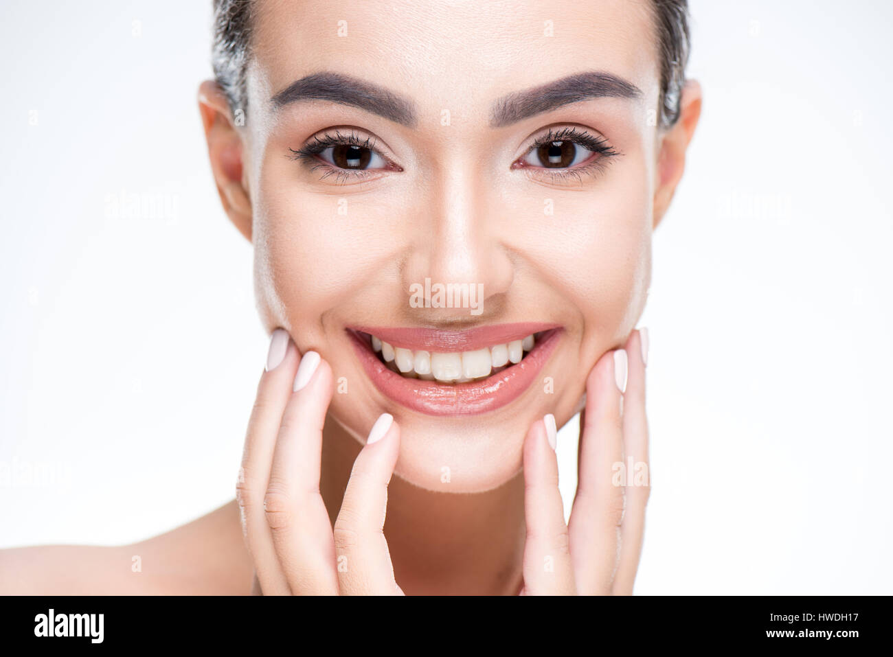 Close up portrait of woman touching face by hands isolated on white ...