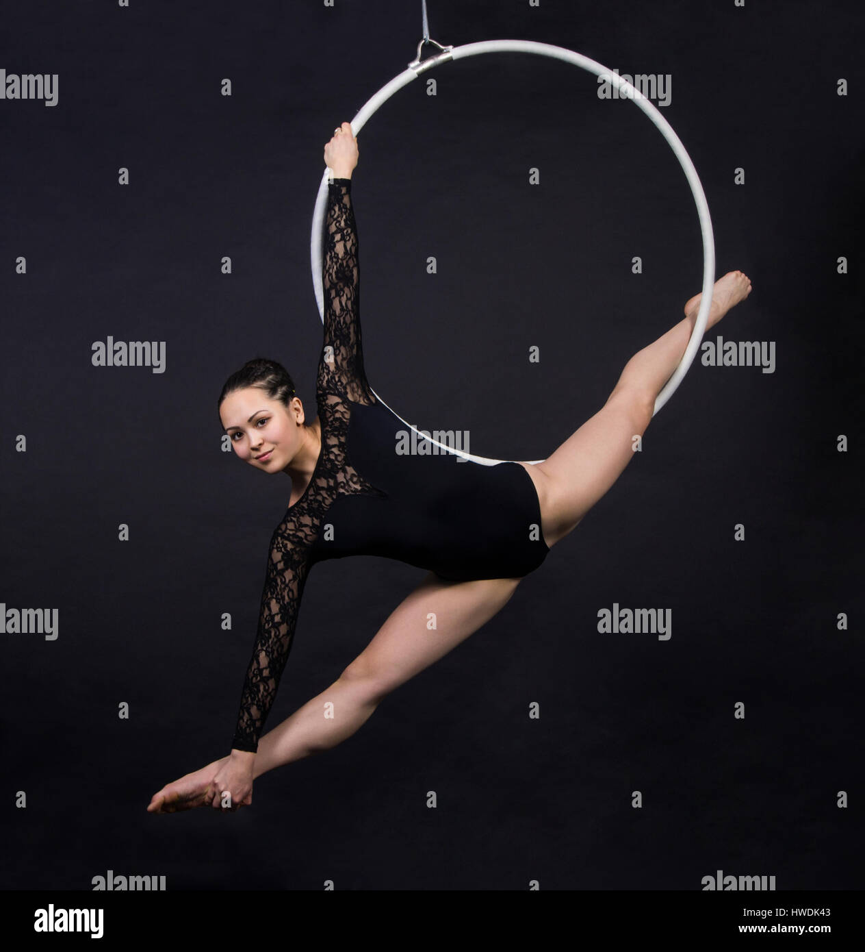 Aerial acrobat in the ring. A young woman performs the acrobatic ...