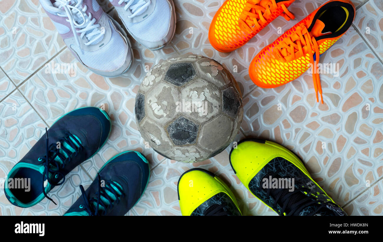 Symbol of Teamwork, Many shoes with ball on ground Stock Photo - Alamy