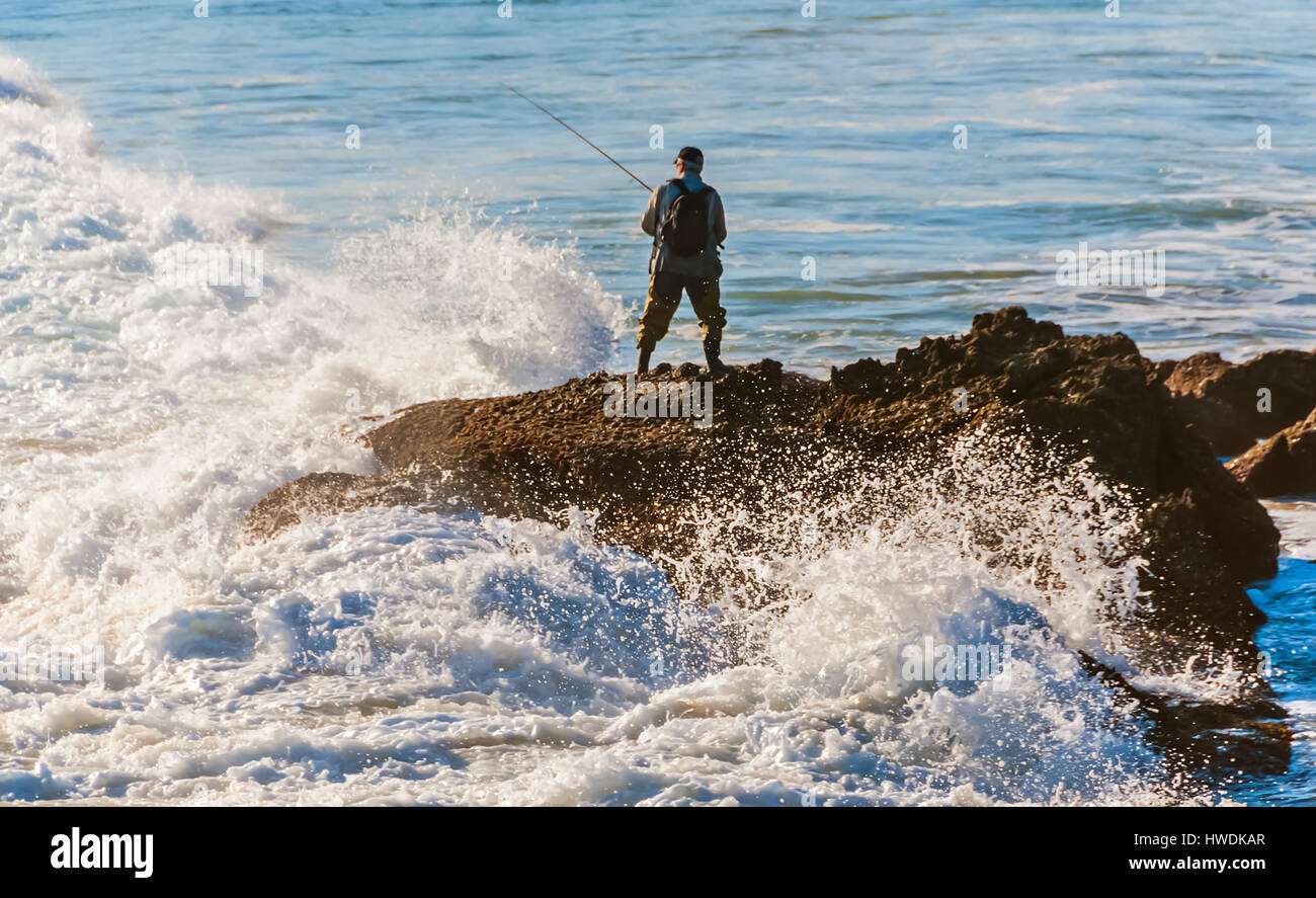 Fishing In The Waves Stock Photo - Alamy
