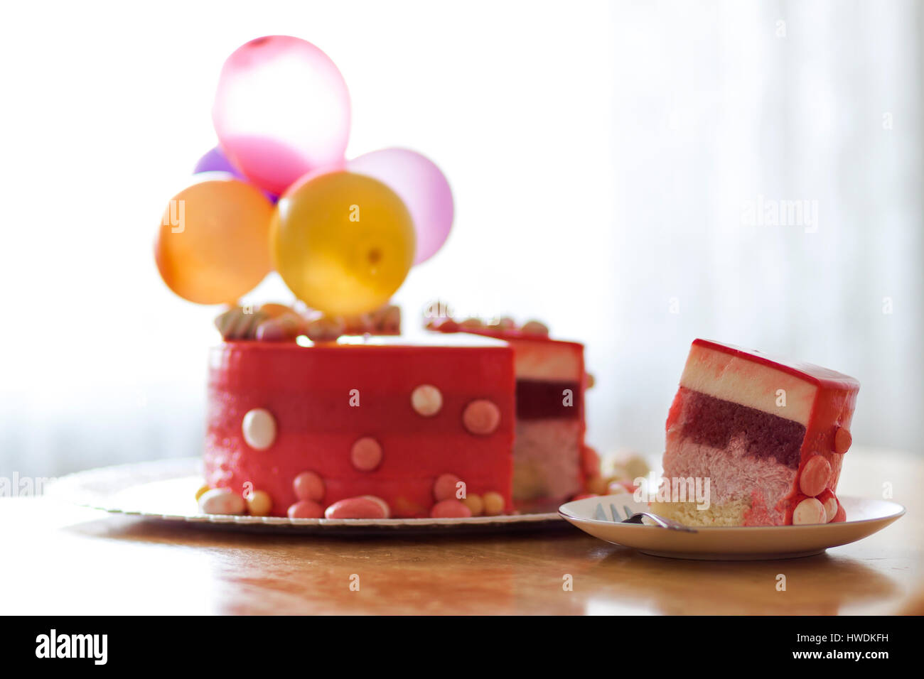 Homemade red birthday cake with air baloons. Slice of a red velvet cake ...