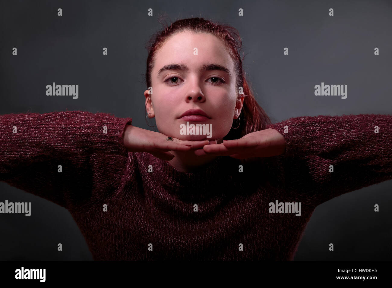 young woman laying her chin on the hands Stock Photo - Alamy