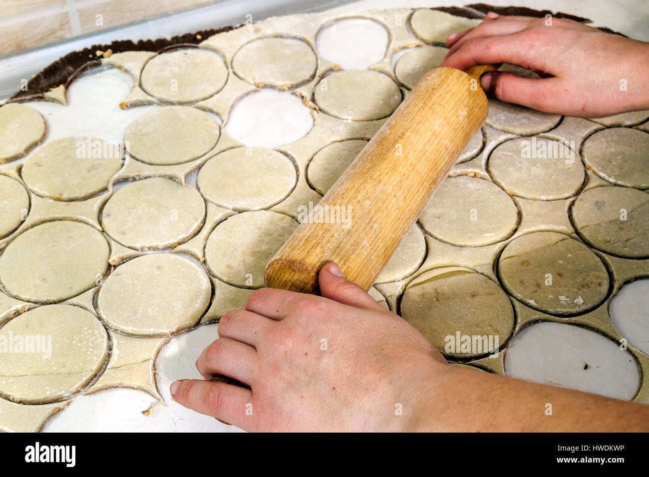 Rolling pin with dough on kitchen table. Preparing dough round ...