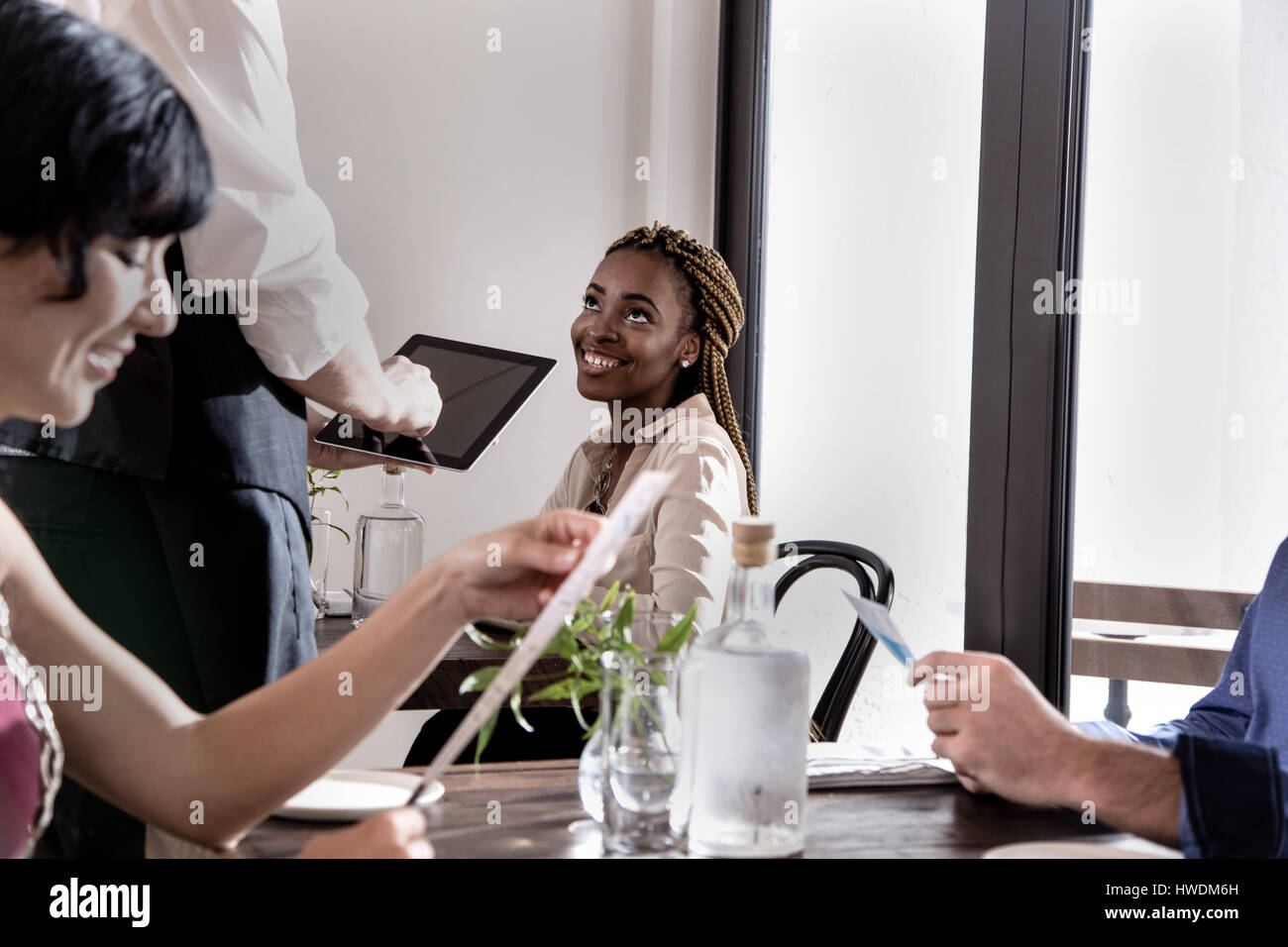 Waiter serving diners in restaurant, waiter using digital tablet Stock ...