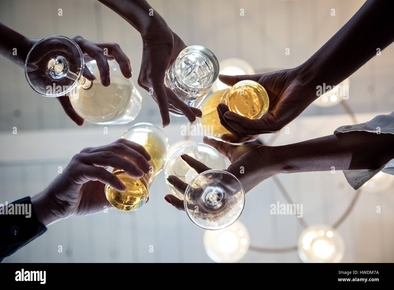 Group of friends making a toast, upward view of hands holding glasses ...