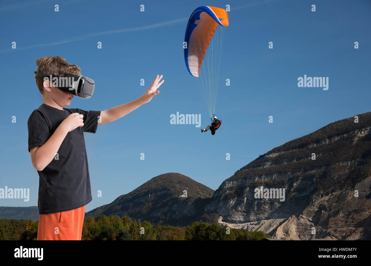 Young boy wearing virtual reality headset, reaching out to touch ...