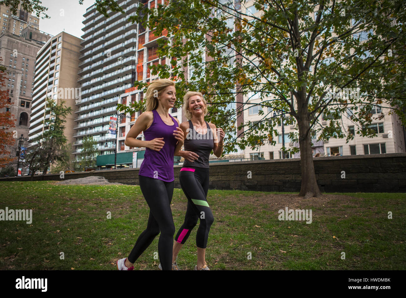 Two mature female friends running together in park Stock Photo - Alamy