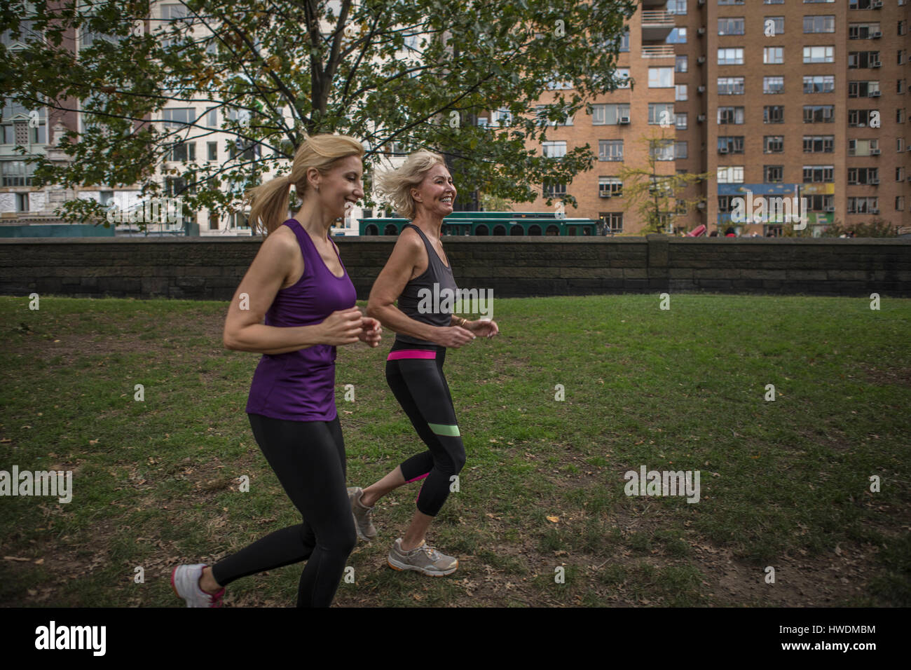 Two mature female friends running together in park Stock Photo - Alamy