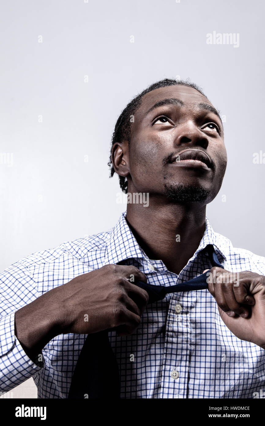 Young man undoing neck tie Stock Photo - Alamy