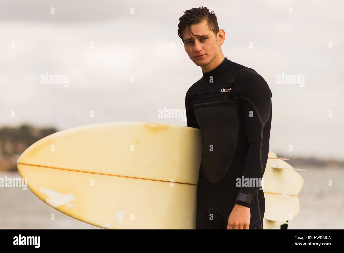 Portrait of young man, holding surfboard Stock Photo - Alamy