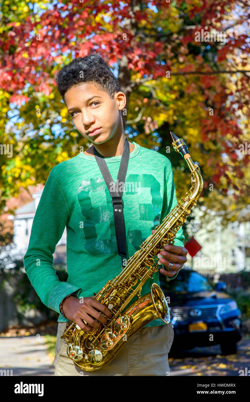 Portrait of teenage boy holding saxophone Stock Photo - Alamy