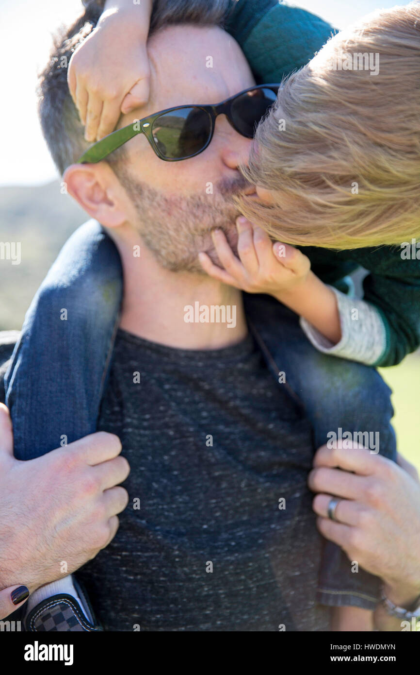 Boy bending forward to kiss father Stock Photo - Alamy