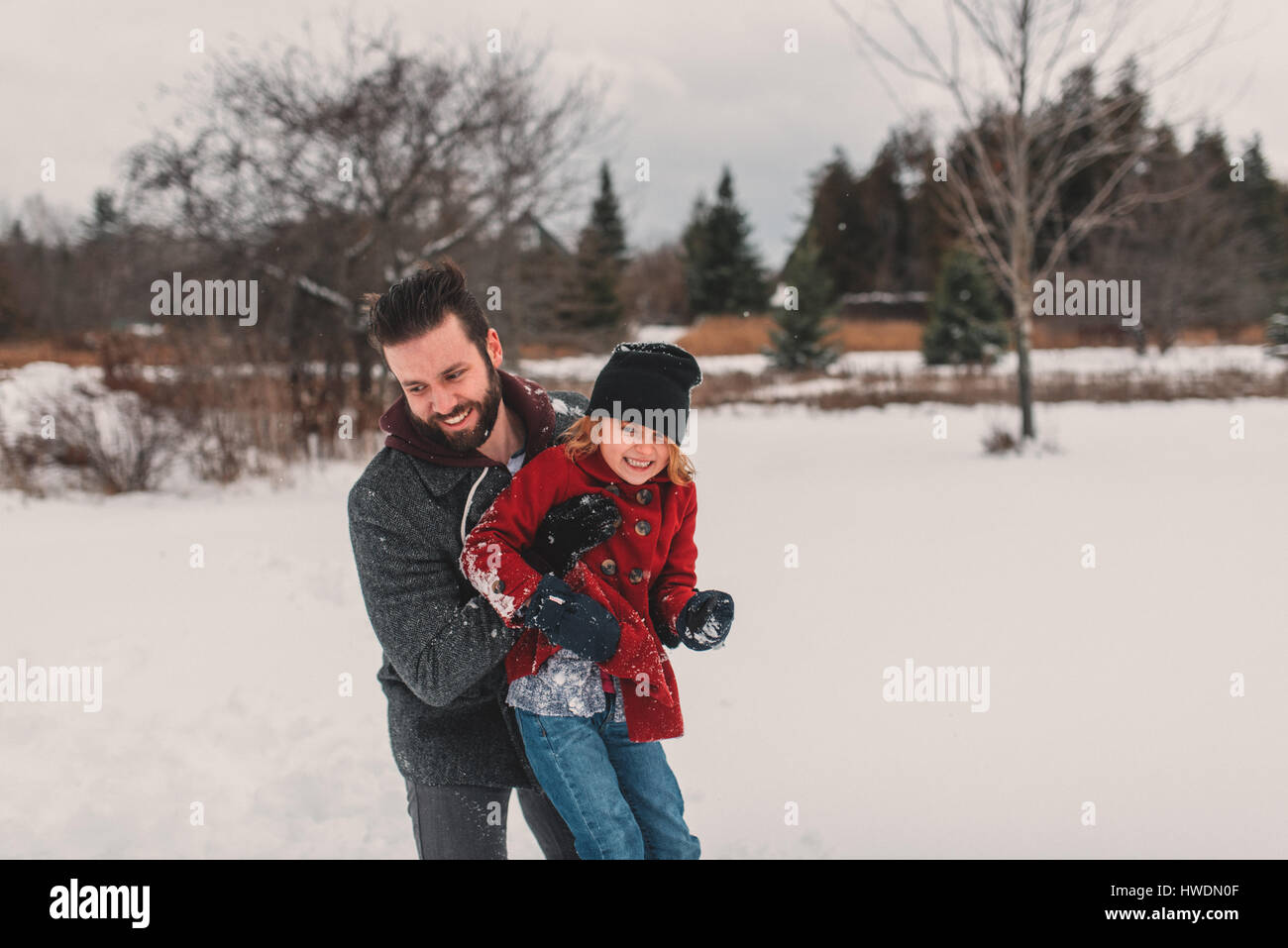 Father and daughter playing in snow Stock Photo - Alamy