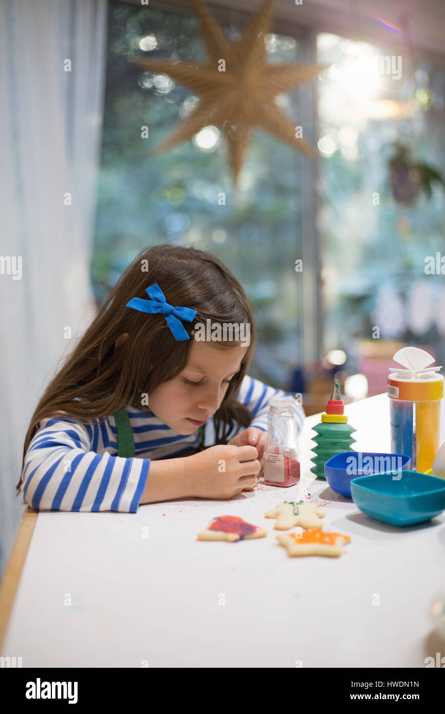 Girl decorating christmas cookies at kitchen counter Stock Photo - Alamy