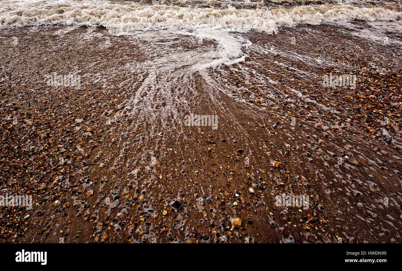 retreating wave and shoreline surf on a shingle beach Stock Photo - Alamy