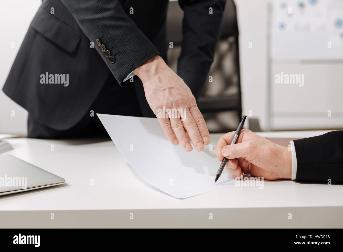 Confident businessman signing the important document in the office ...