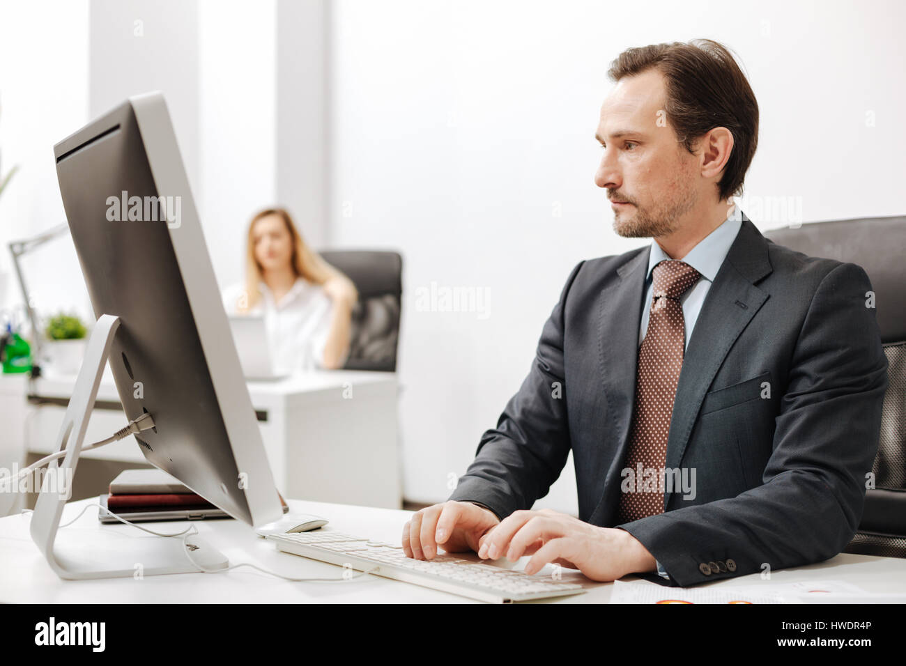 Confident businessman using computer in the office Stock Photo - Alamy