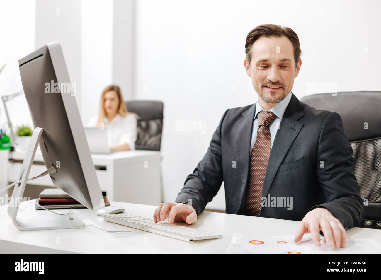 Cheerful office manager using contemporary gadgets in the office Stock ...