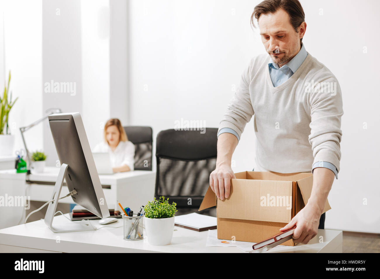 Confused staff member packing the box and leaving the company Stock ...