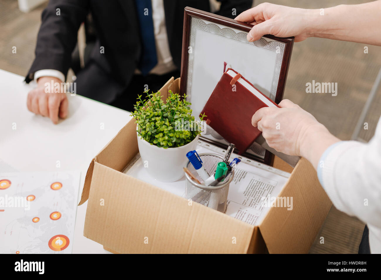 Fired employee packing the box and quitting the job Stock Photo - Alamy