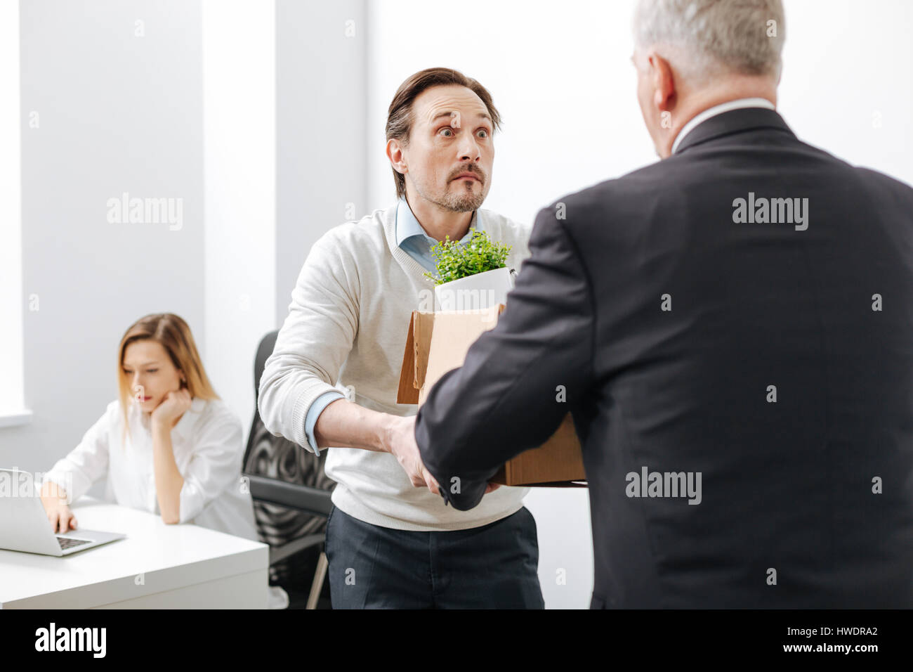 Shocked employee receiving the box with belongings from the employer ...