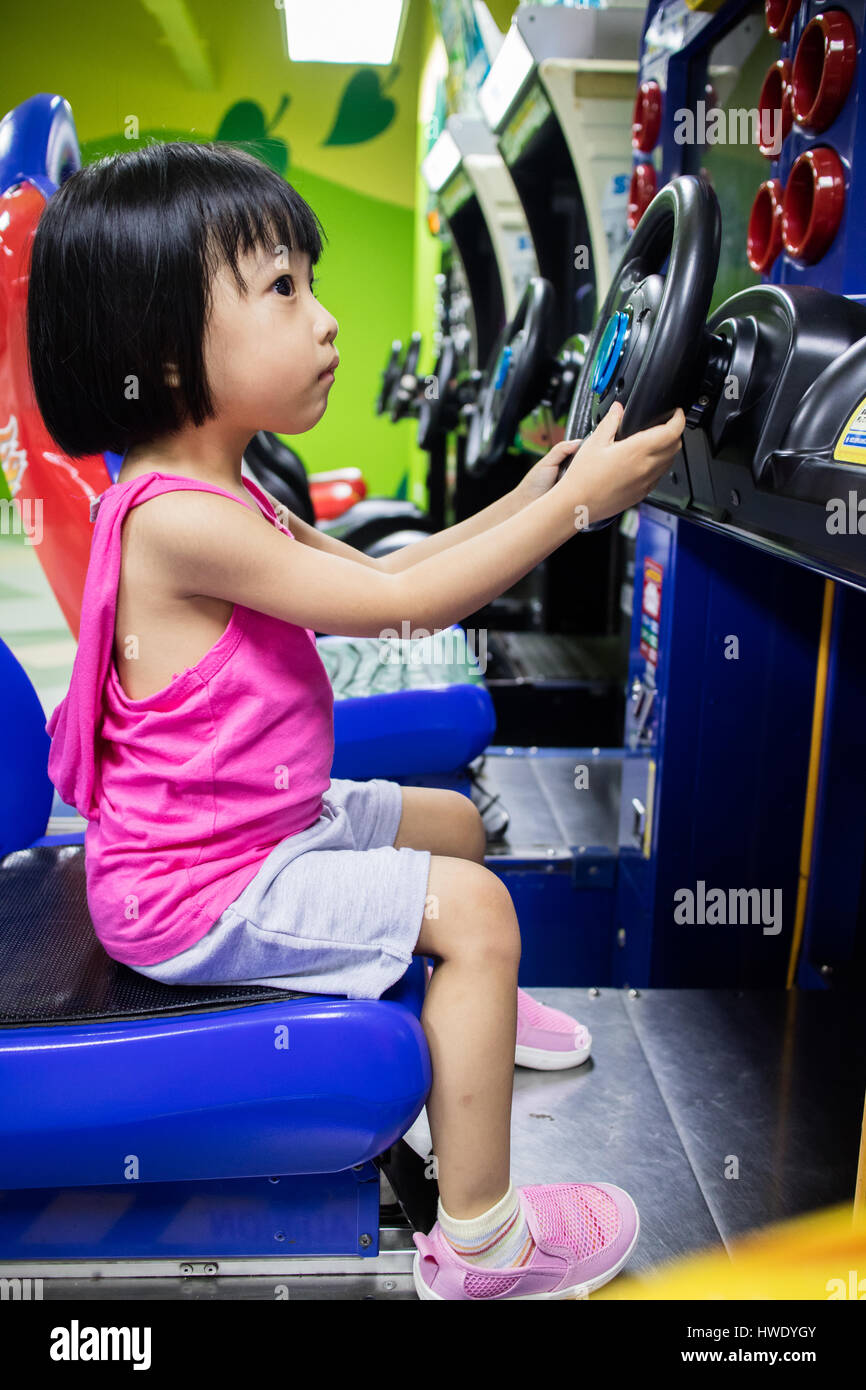 Asian Little Chinese Girl Playing Arcade Game Machine at a indoor ...
