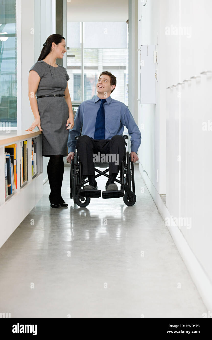 Disabled office worker with colleague Stock Photo - Alamy
