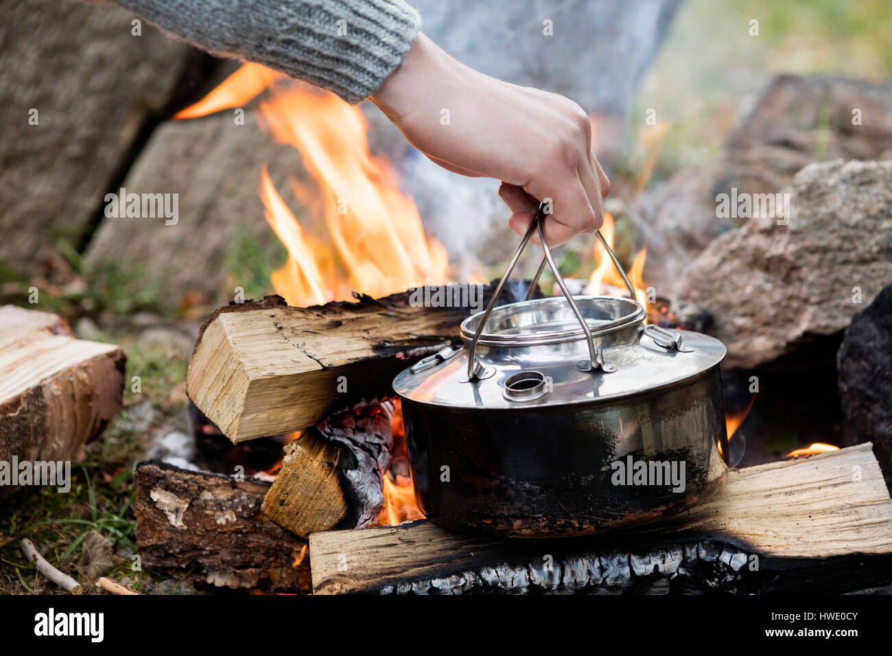 Hand Holding Cooking Pot Over Bonfire Stock Photo - Alamy