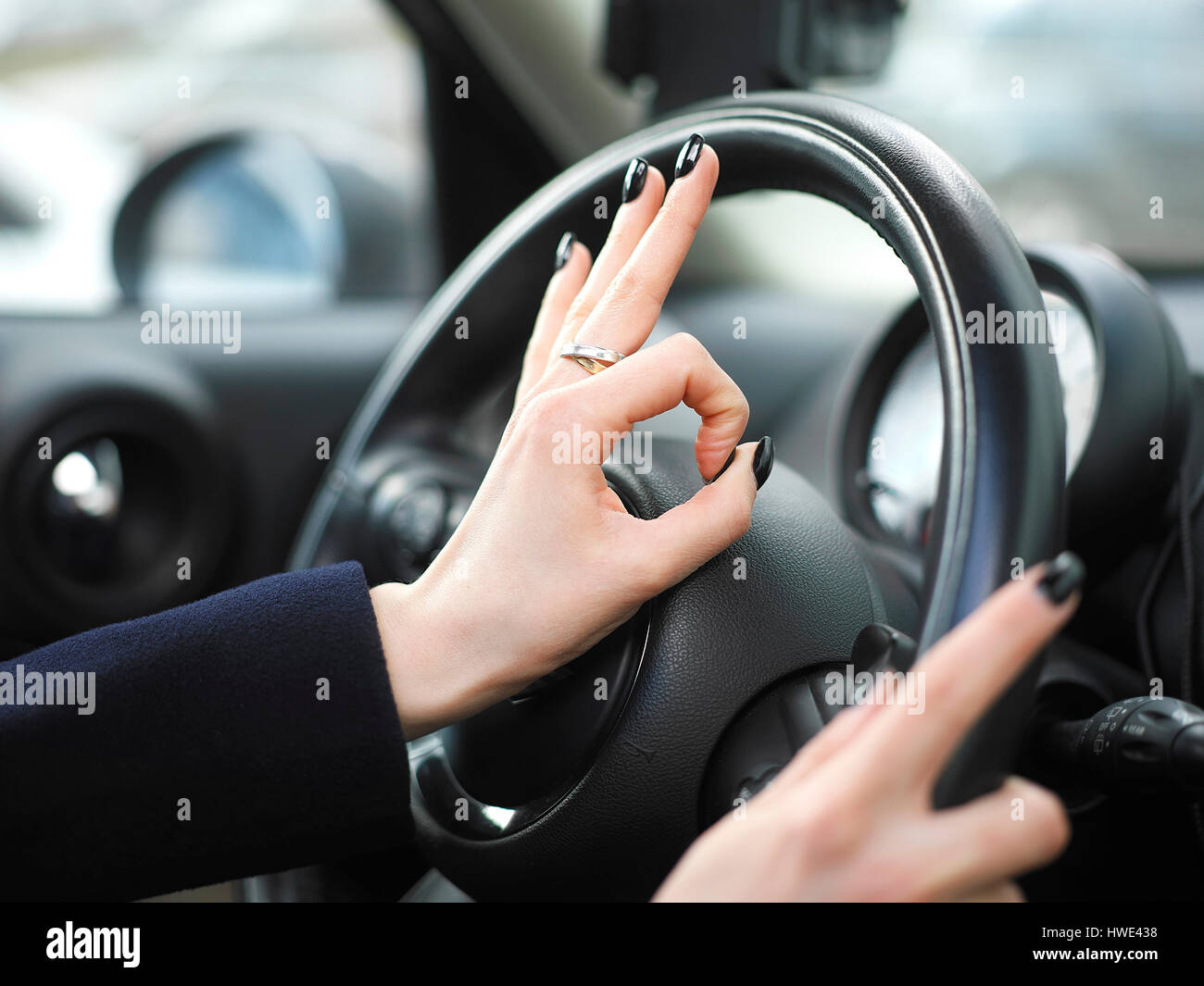 Female driver showing ok sign while driving, shallow depth of field ...