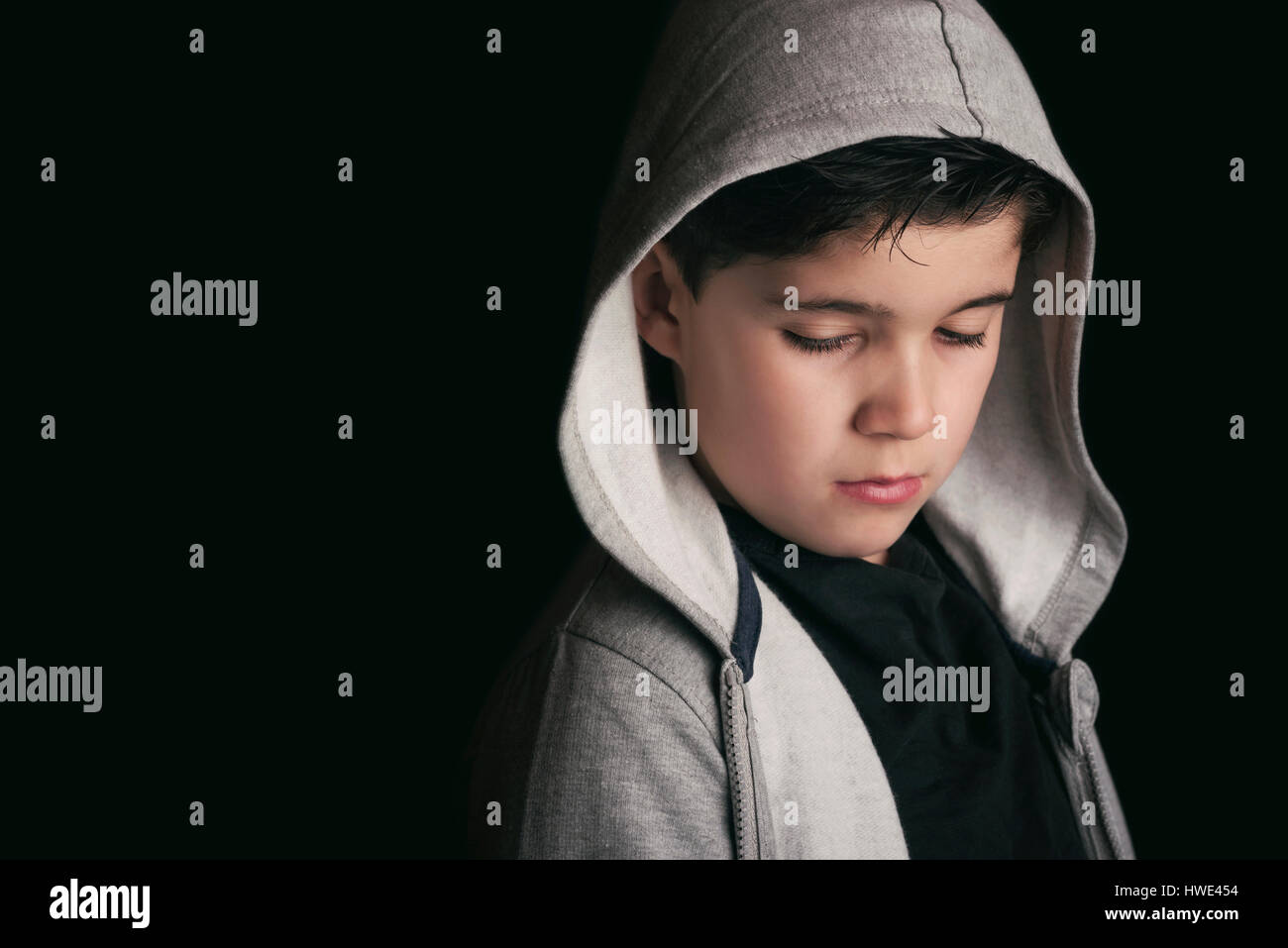 Sad boy on black background Stock Photo - Alamy