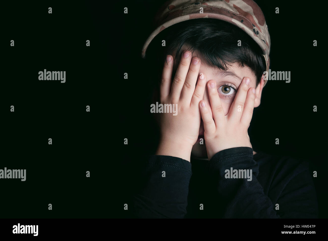 Scared boy on black background Stock Photo - Alamy