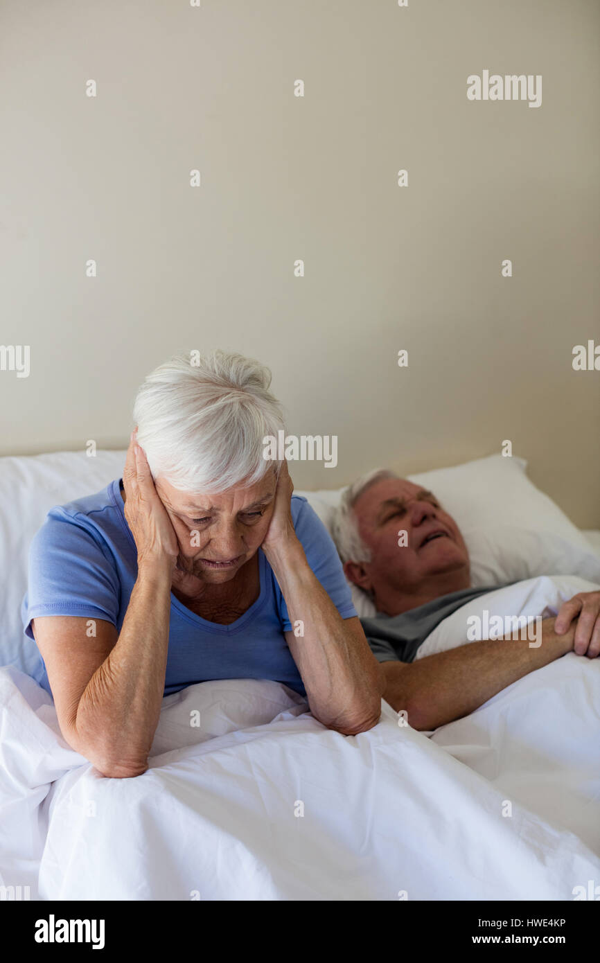 Senior woman getting disturbed with man snoring on bed in bedroom Stock ...