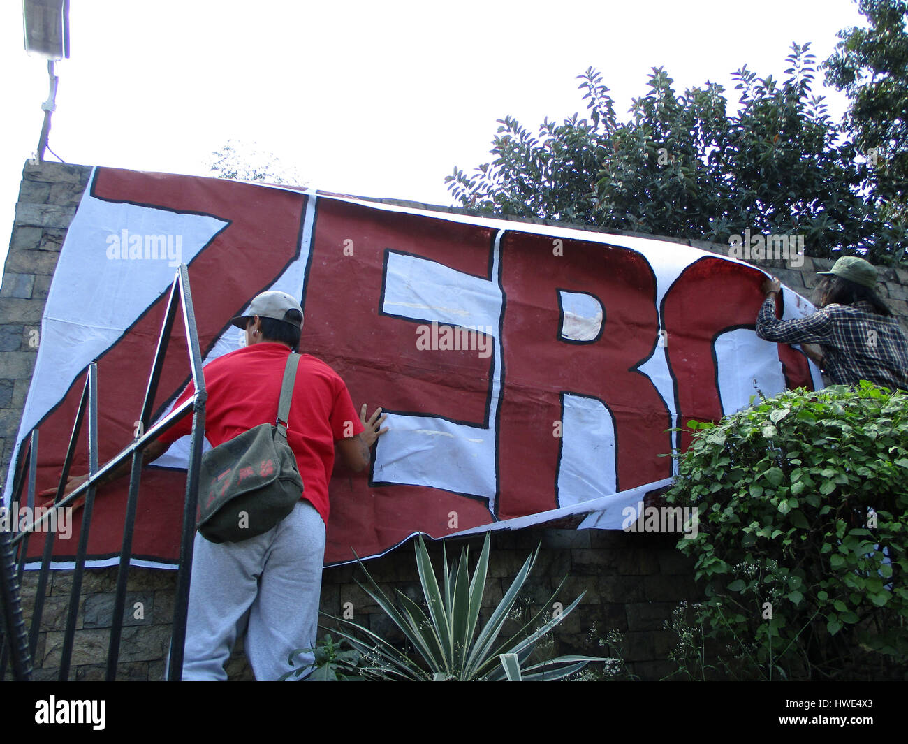 Protesters from an urban poor group unfurl a banner that reads, "ZERO ...