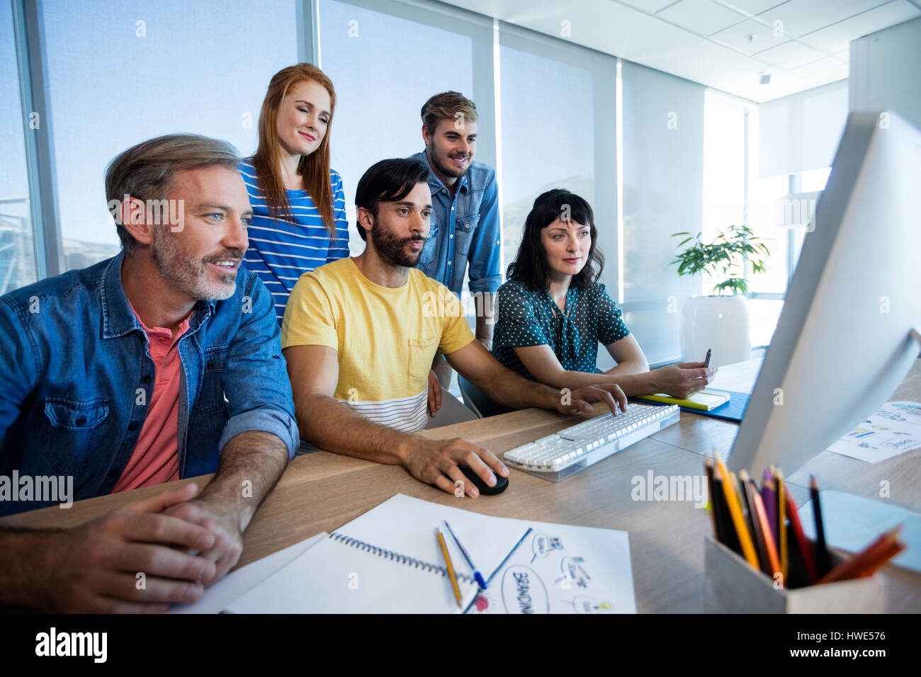 Creative business team working together on desktop pc in office Stock ...