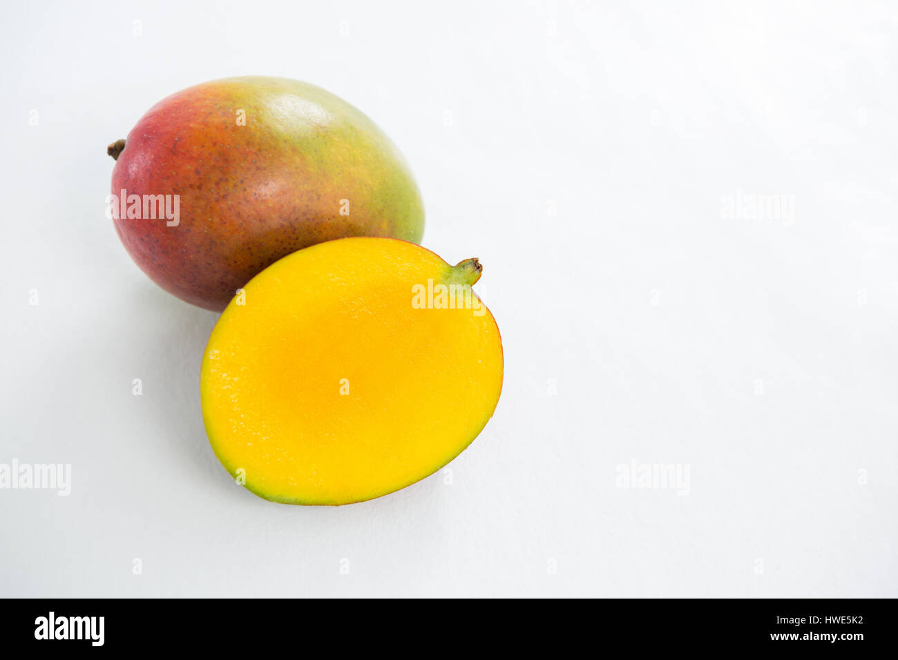 Close-up of halved mango on white background Stock Photo - Alamy