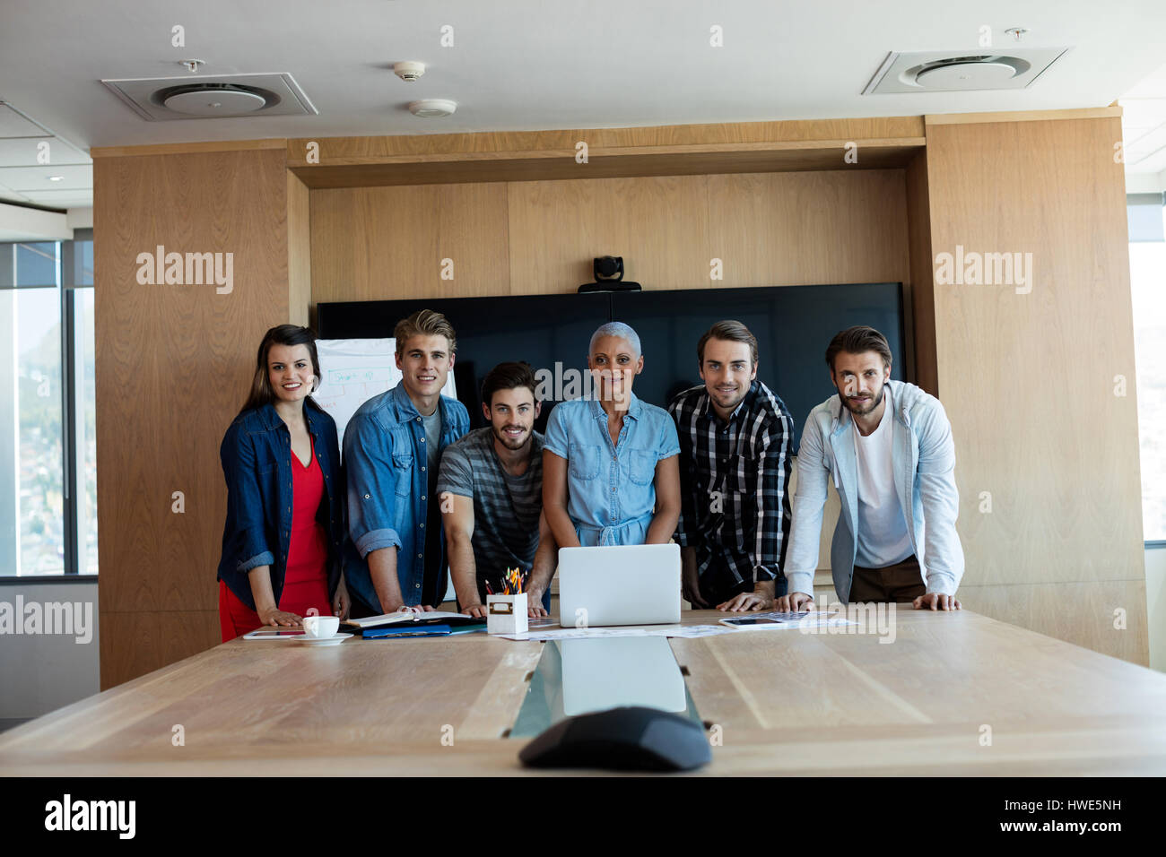 Portrait of creative business team standing in conference room with ...