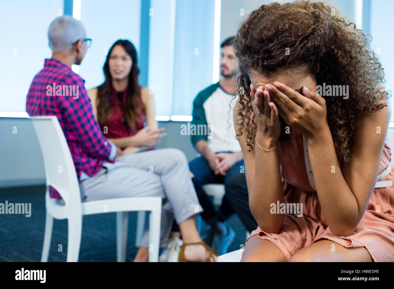 Woman crying while creative business team in background at office Stock ...