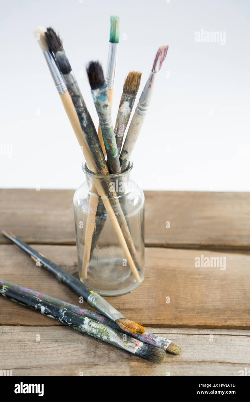 Various paintbrush in glass jar against white background Stock Photo ...